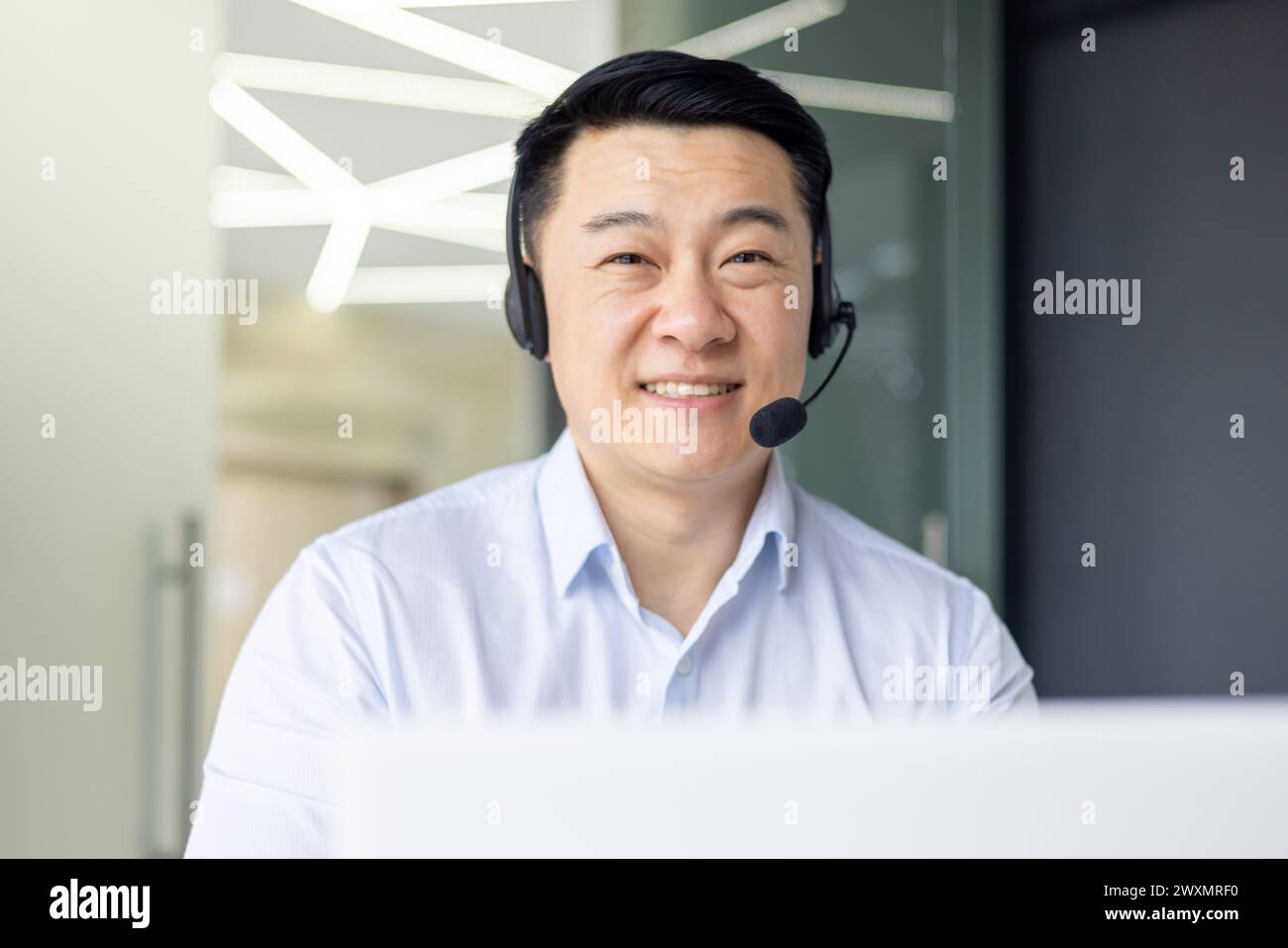 A professional Asian man is engaged in his work at a modern office ...