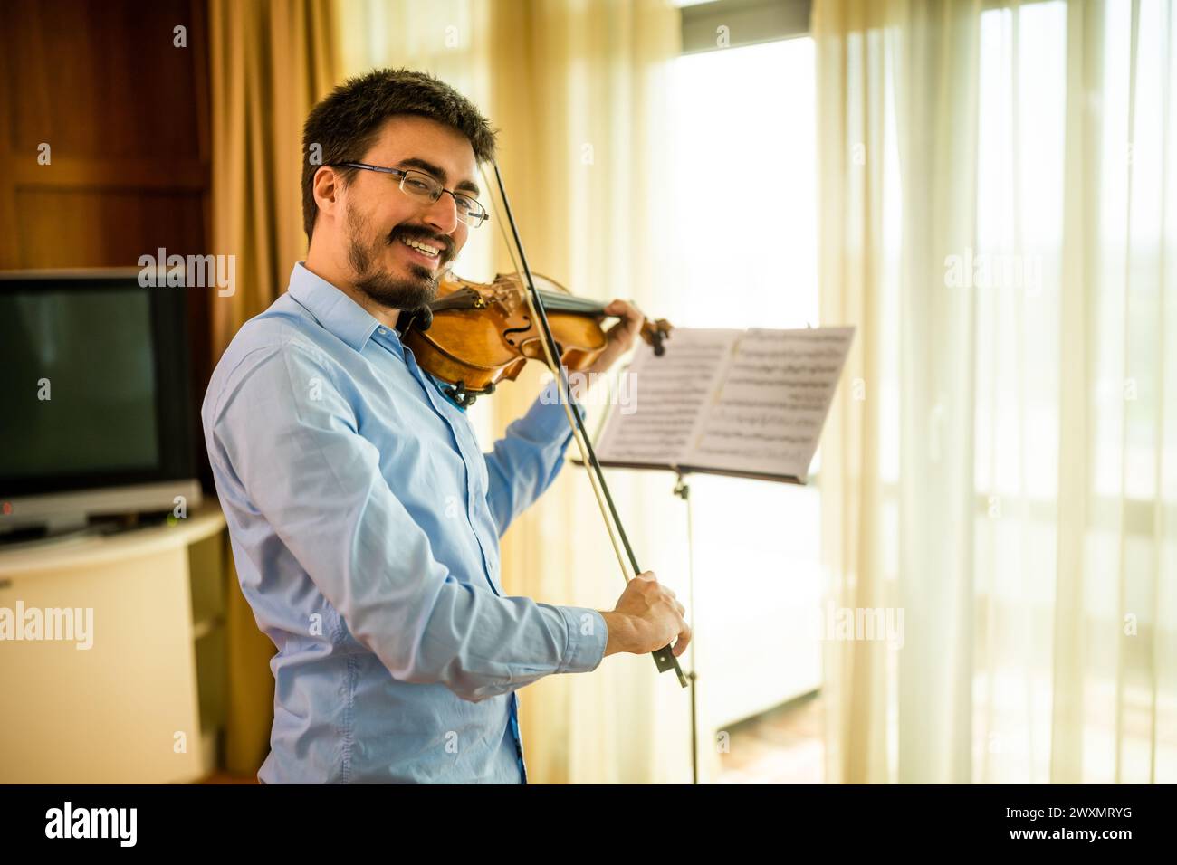 Smiling man playing violin hi-res stock photography and images - Alamy