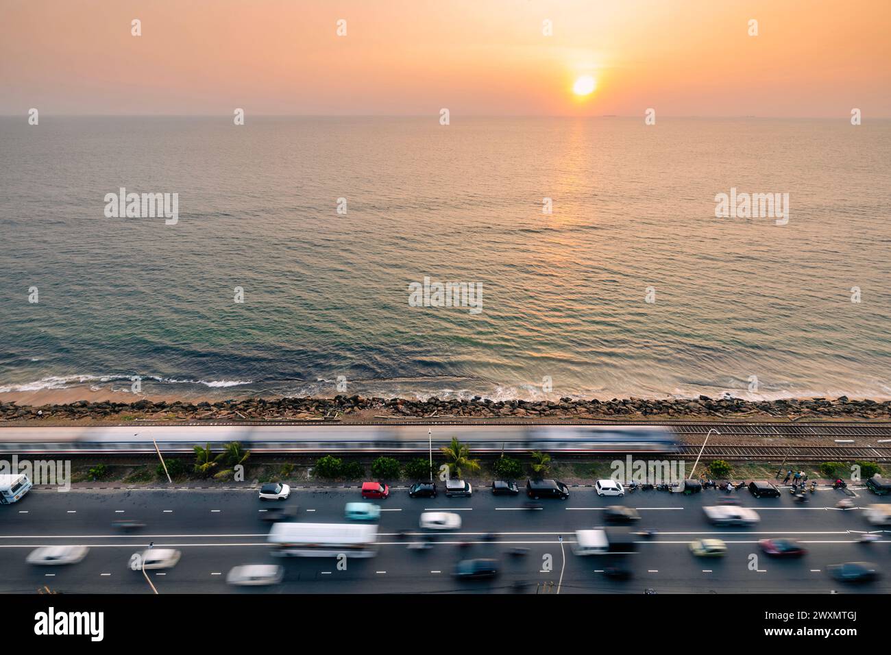 Road and railway track along coast at sunset over Indian ocean. Train ...