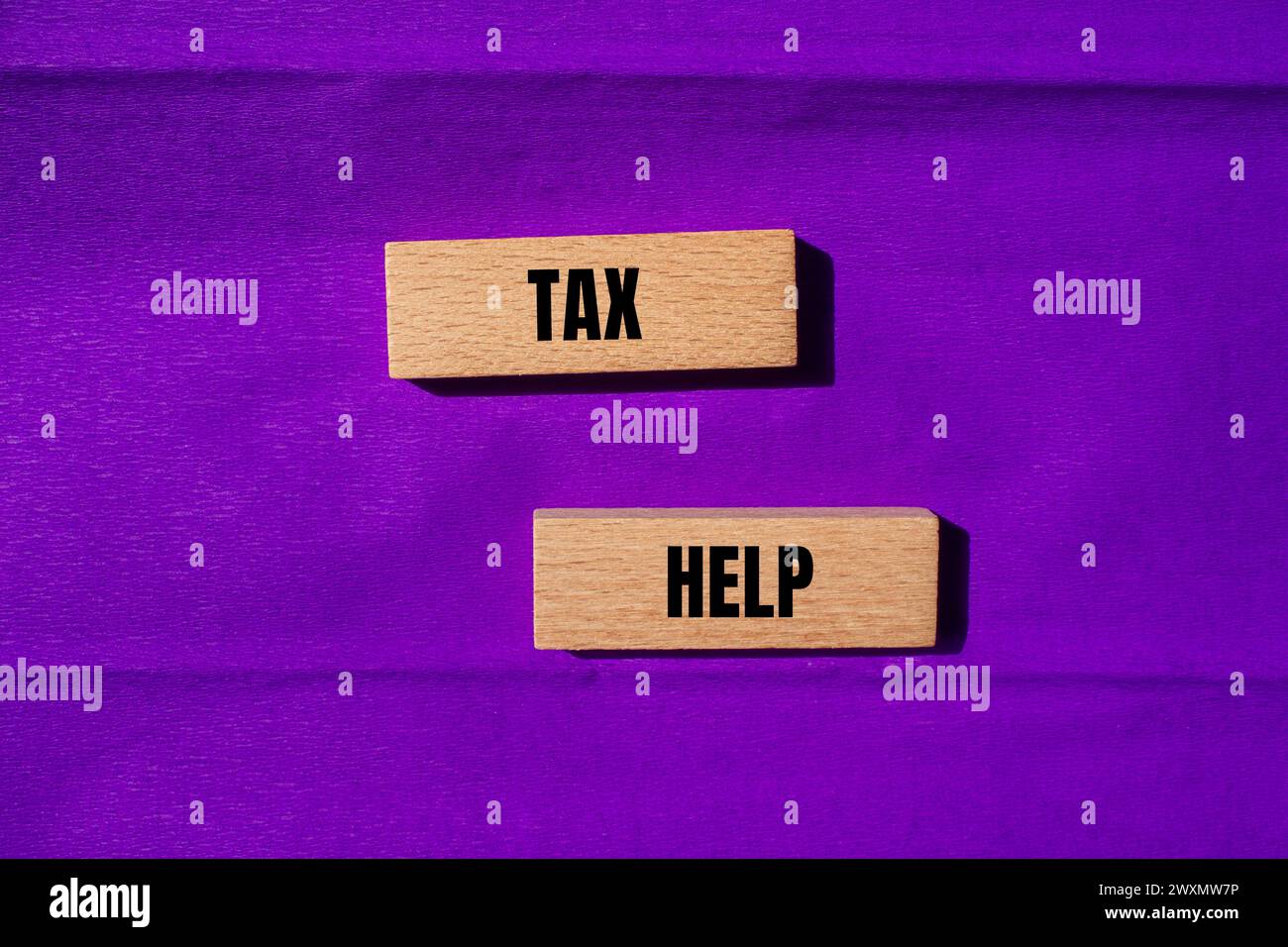 Tax help words written on wooden blocks with purple background ...