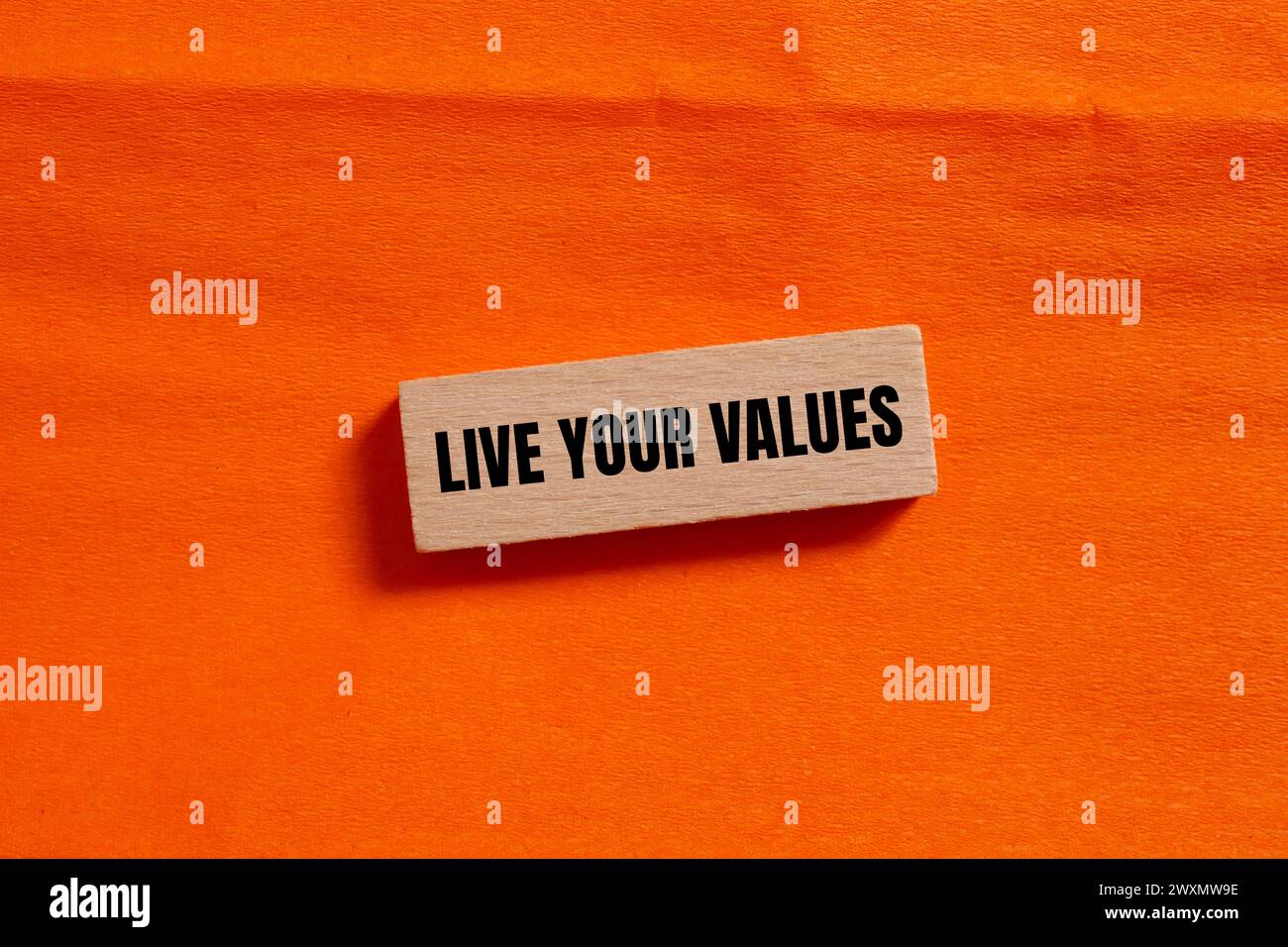 Live your values words written on wooden block with orange background ...