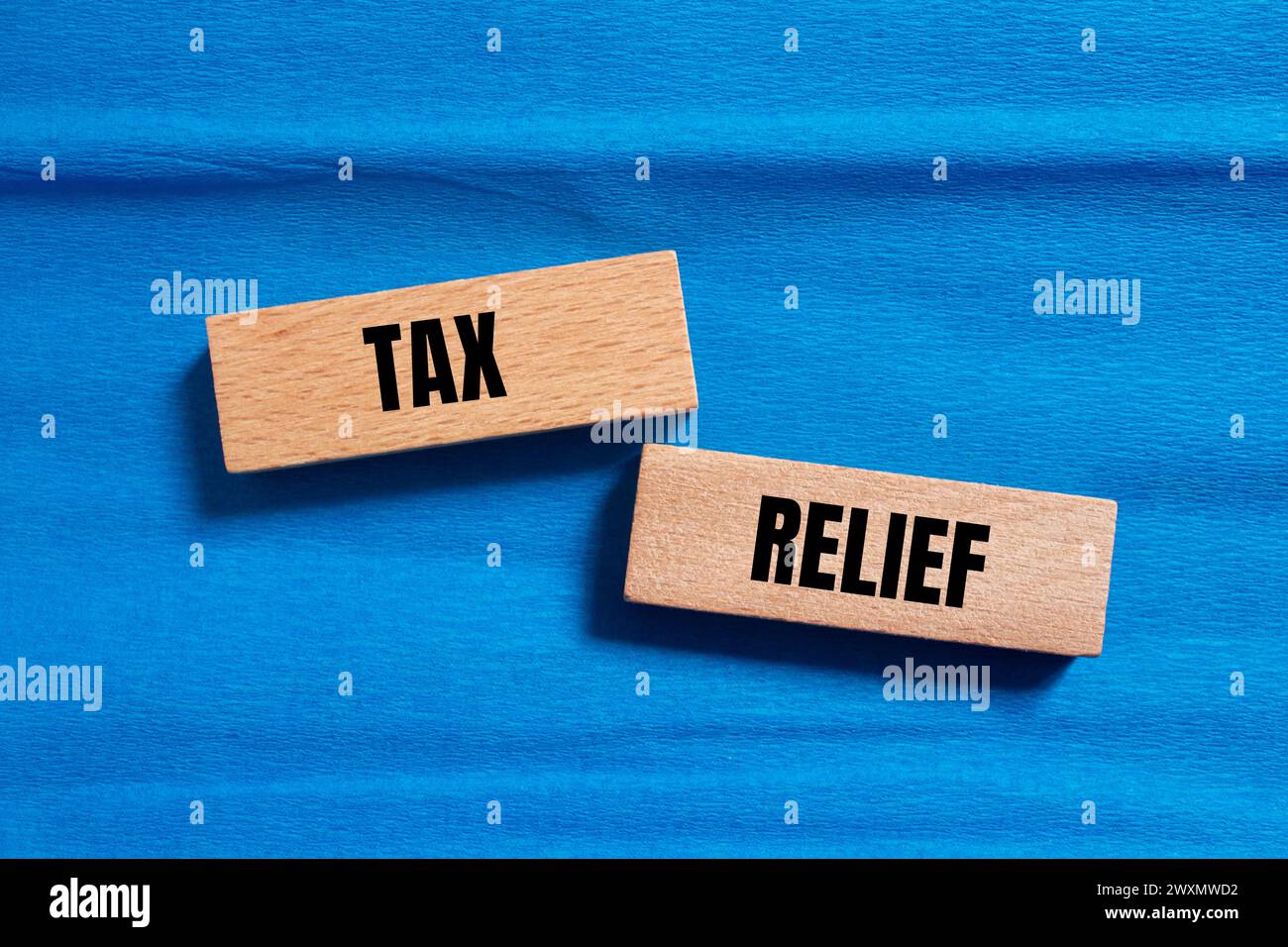Tax relief words written on wooden blocks with blue background ...
