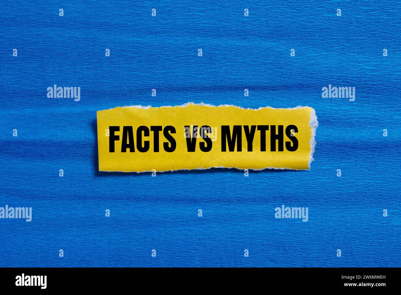 Facts vs myths words written on yellow torn paper with blue background ...