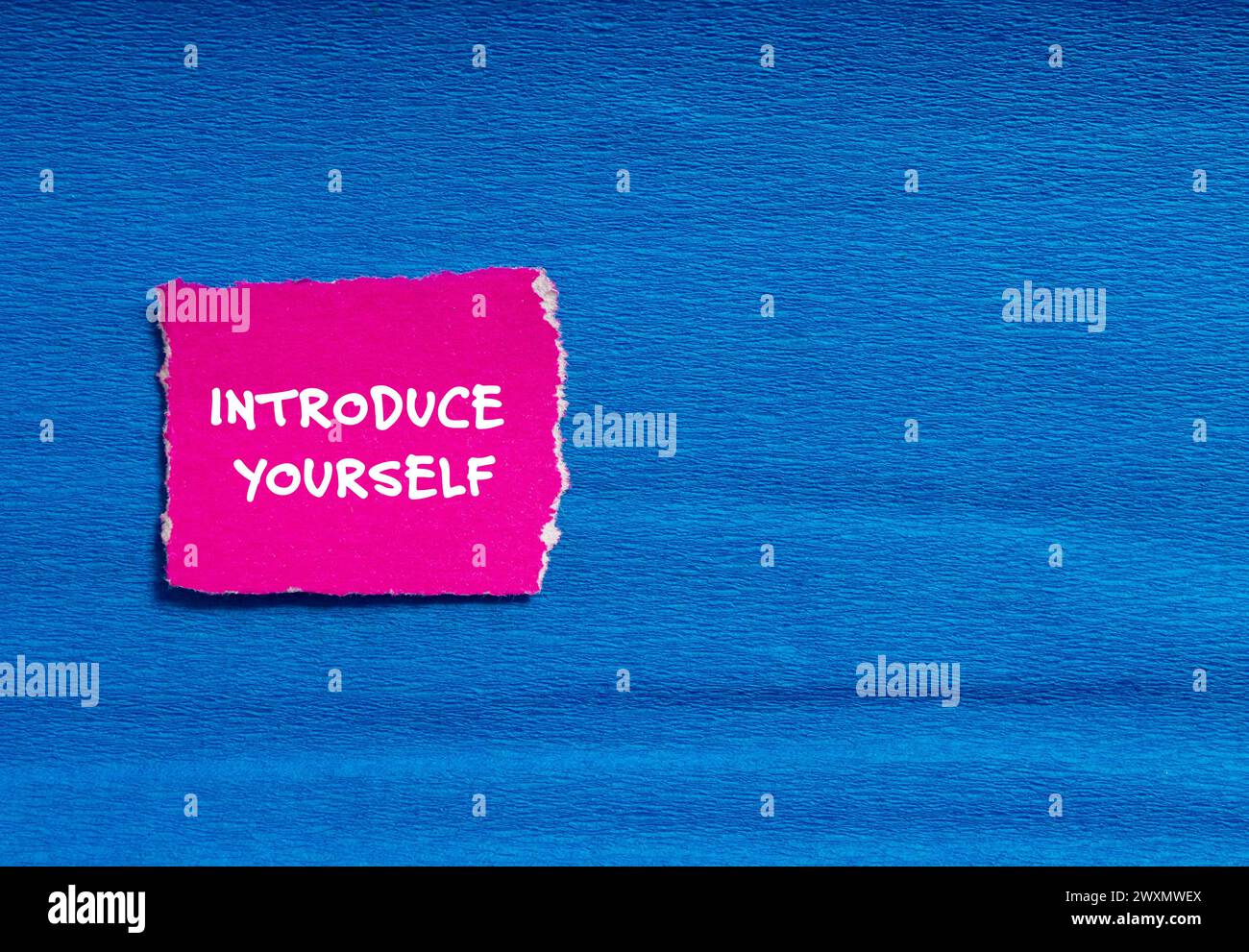 Introduce yourself words written on pink torn paper with blue ...