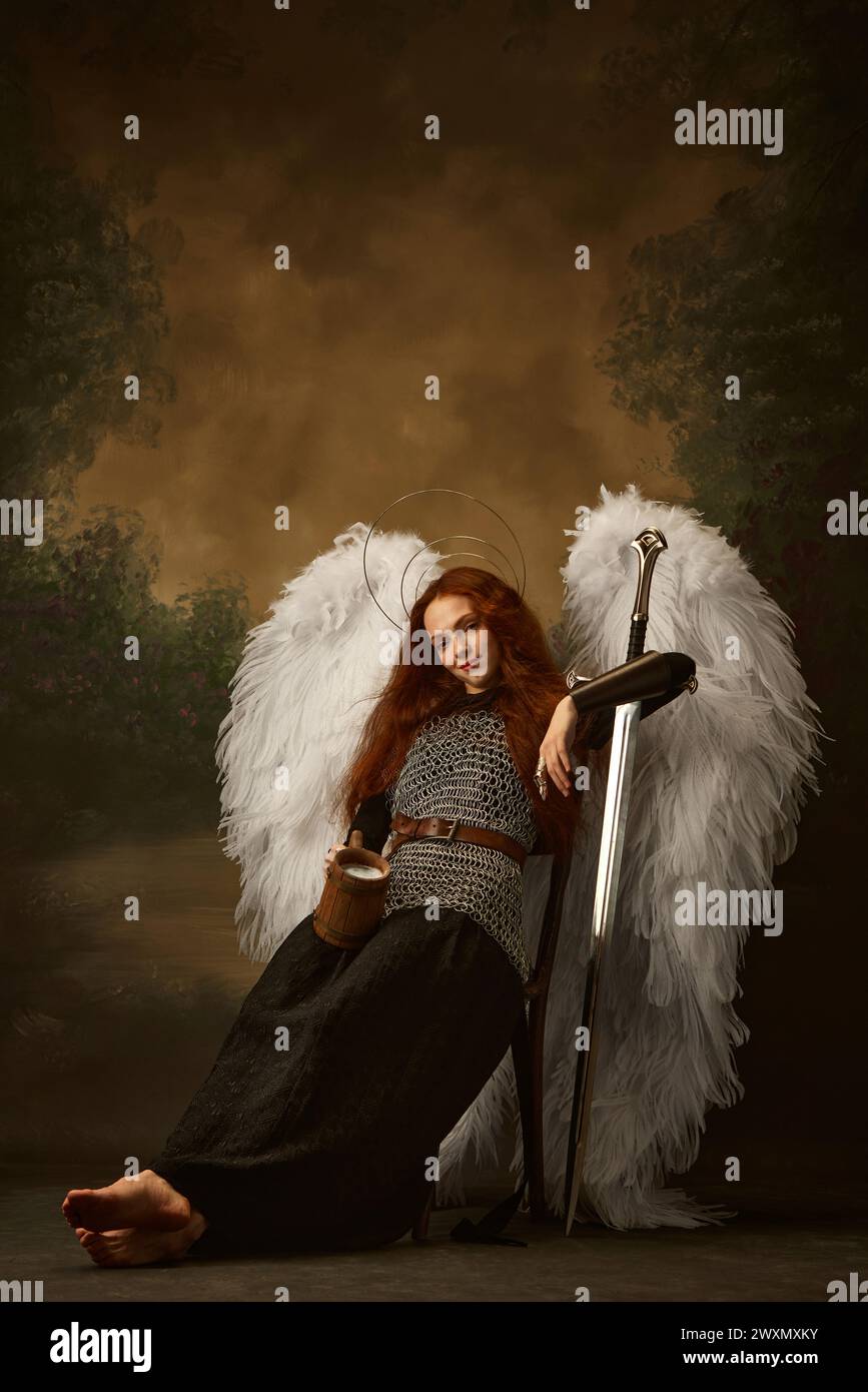 Redhead angel in chainmail with sword, with large white wings and ...