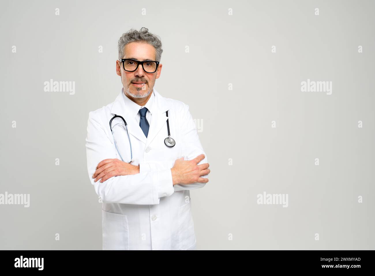 A senior doctor presents a strong and assuring presence, arms folded ...
