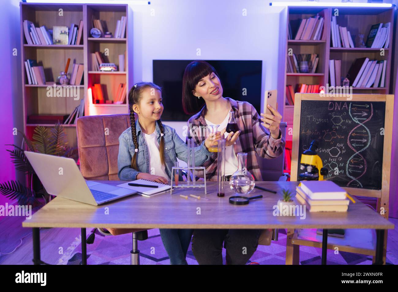 Young woman and little cute girl filming video of their scientific ...