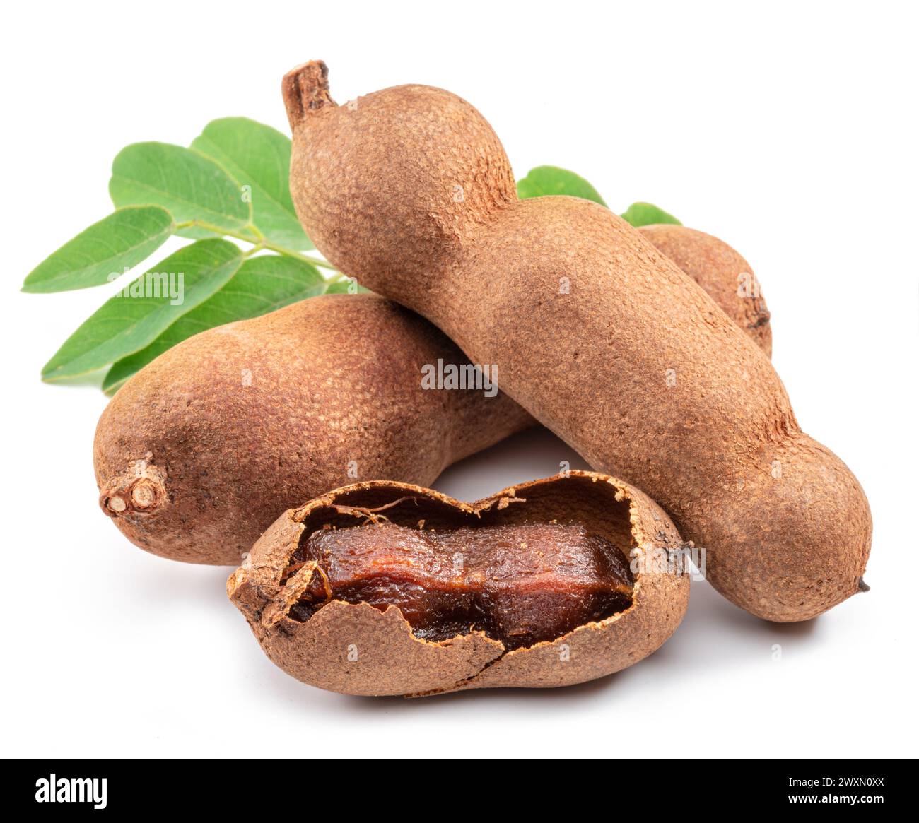 Tamarind fruits and one cracked tamarind with brown pulp in the ...