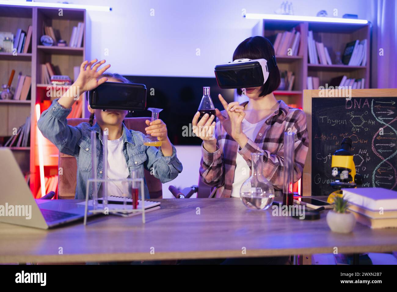 Caring woman and small kid girl improving knowledge using vr glasses at ...