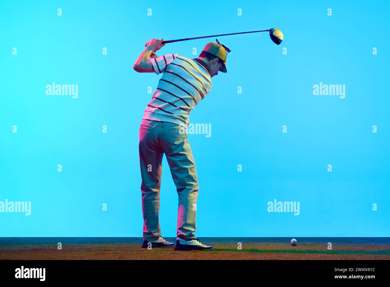 Rear view portrait of focused golfer in retro outfit with golf club ...