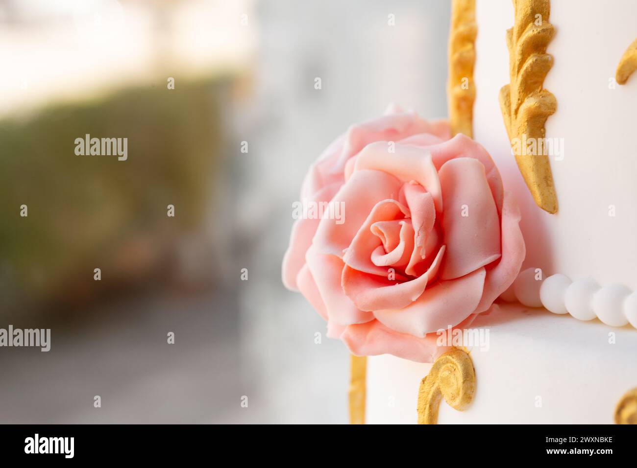 a beautifully crafted fondant rose adorns a wedding cake, enhanced by ...