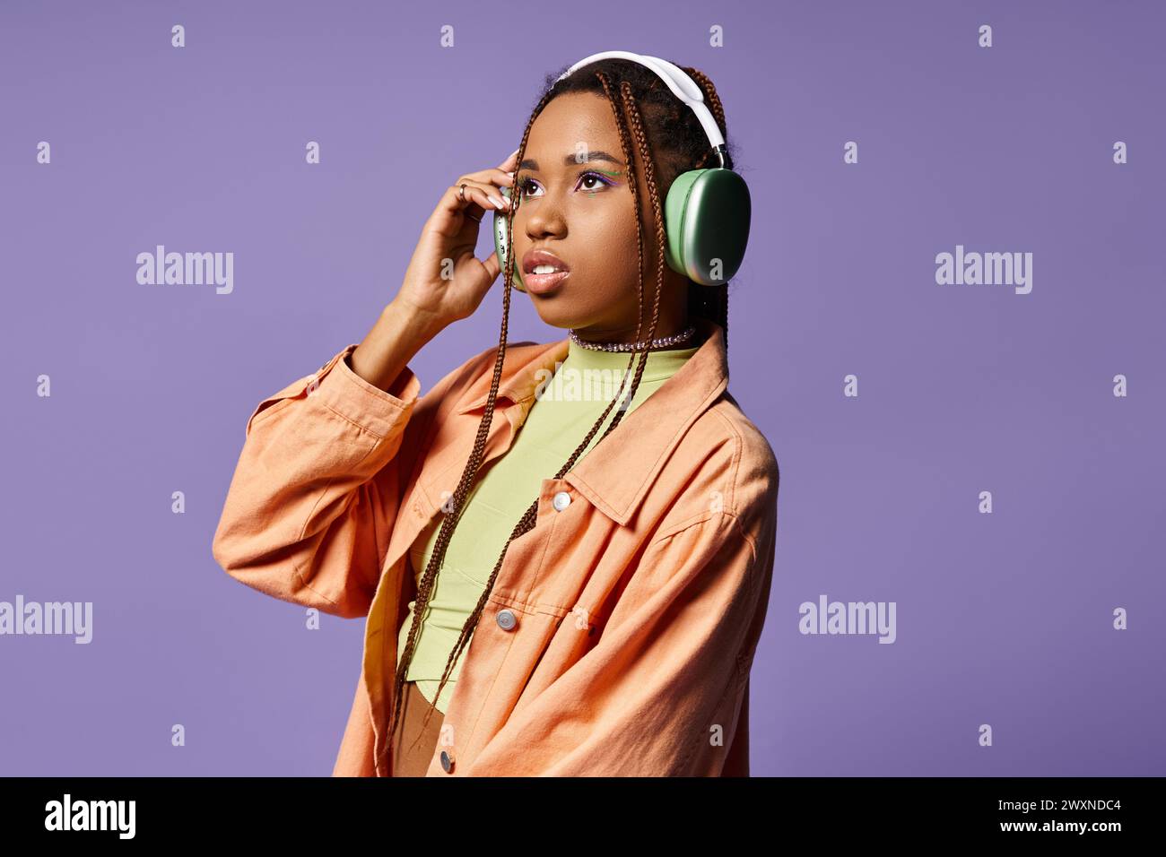 dreamy african american woman in 20s listening music in wireless ...