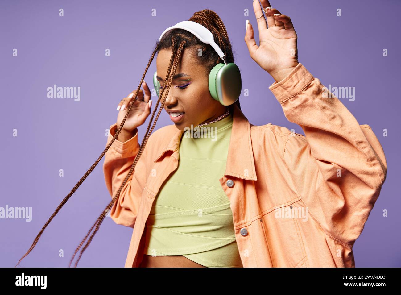pleased african american girl in 20s listening music in wireless ...
