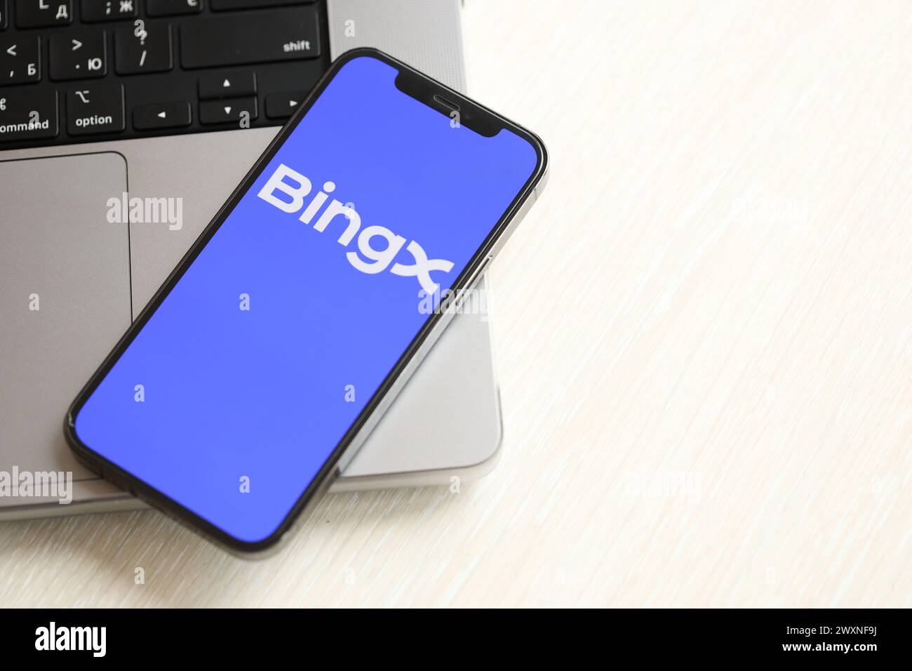 KYIV, UKRAINE - MARCH 15, 2024 BingX logo on iPhone display screen on MacBook panel ...