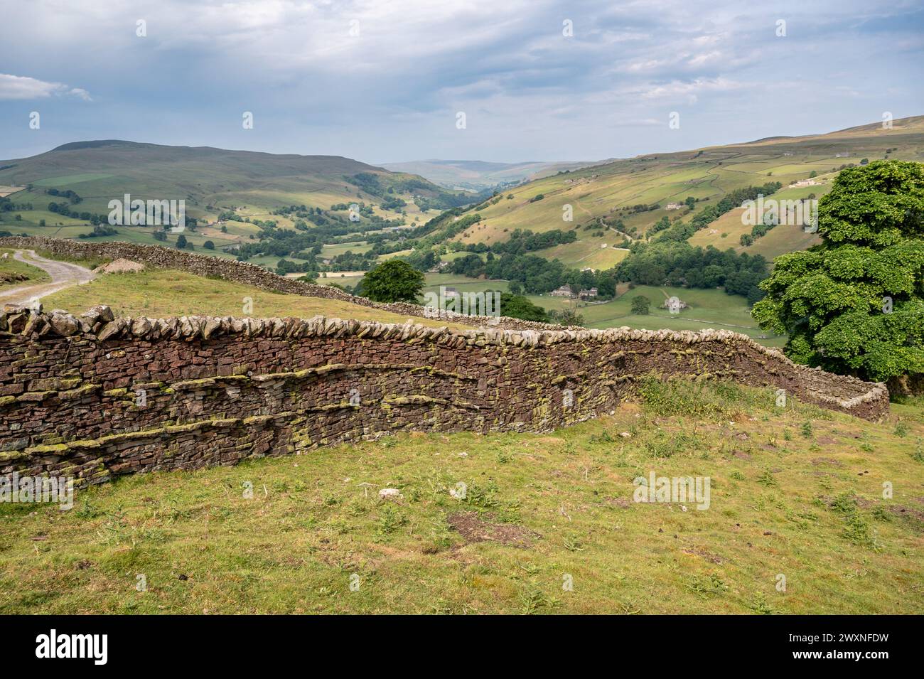 Stone wall in the middle of a rural field between the mountains in ...