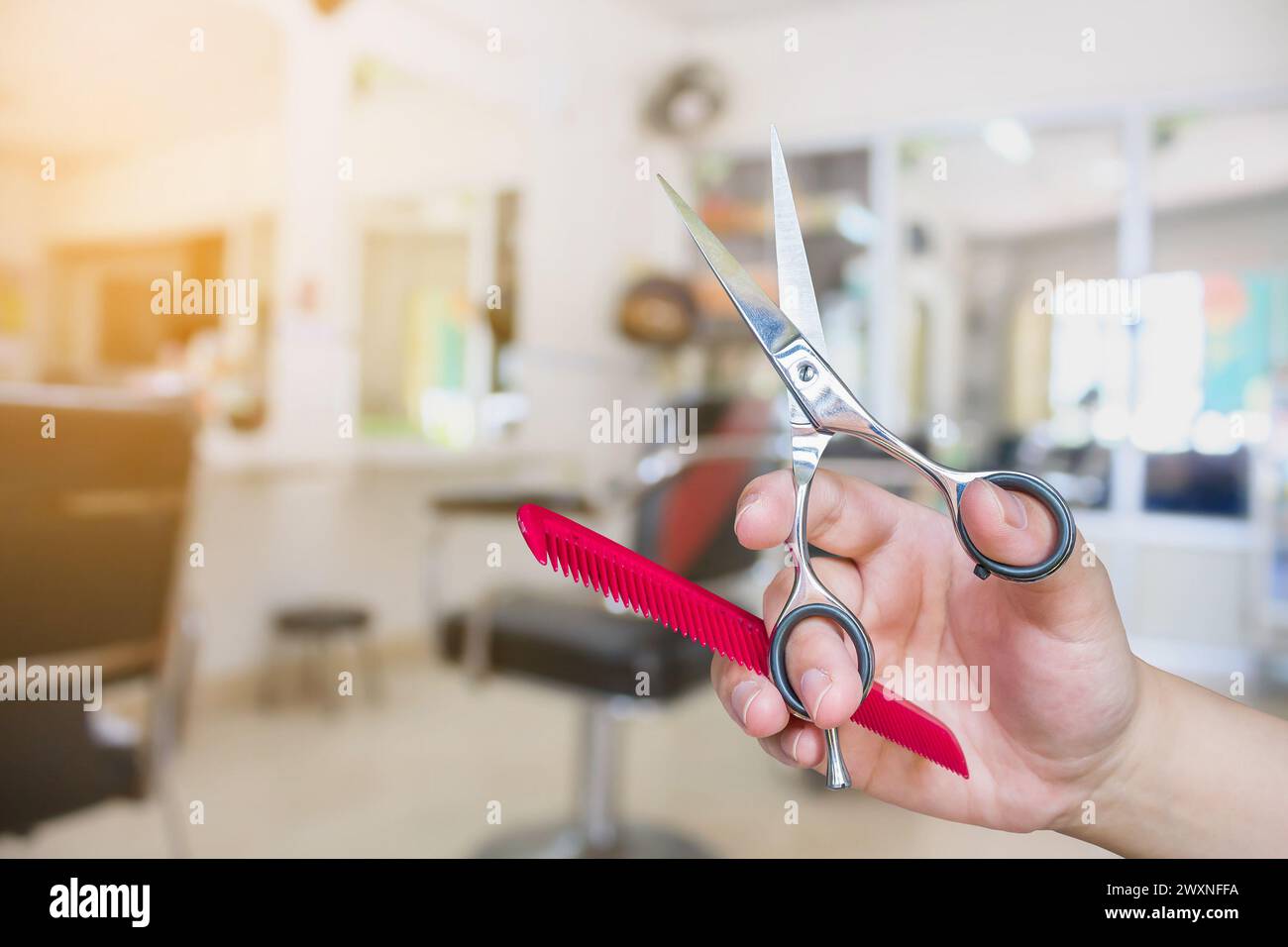 Hairdresser's hand hold scissors with salon beauty interior blur ...