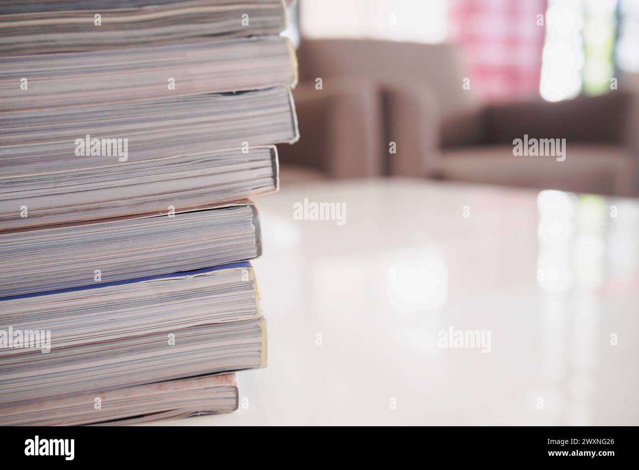 pile of magazines stack on white table in living room, close up Stock Photo - Alamy