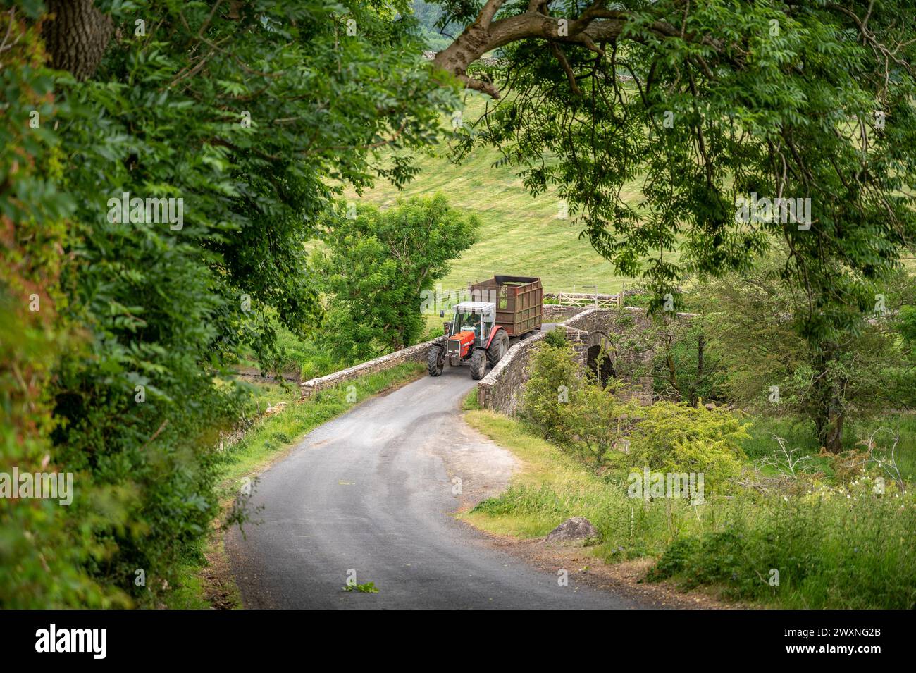 Tractors pulling wagons of haylage England Stock Photo - Alamy
