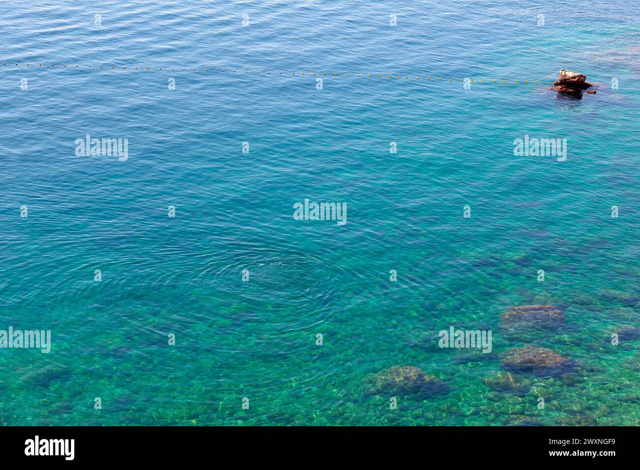 Turquoise sea water background. Transparent water with rocks on the ...