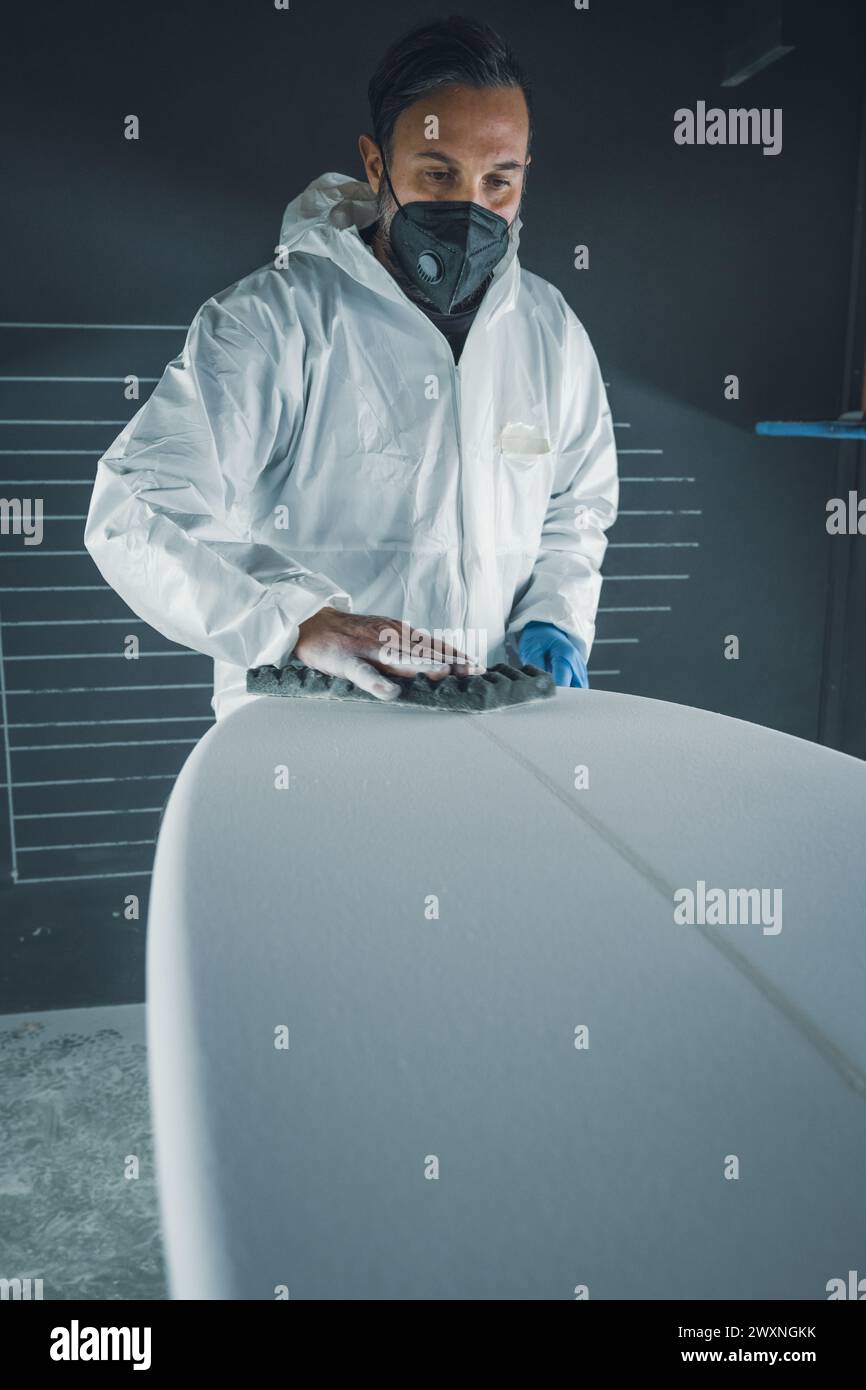 Surfboard manufacturing, Shaper working on board details. Concept of ...