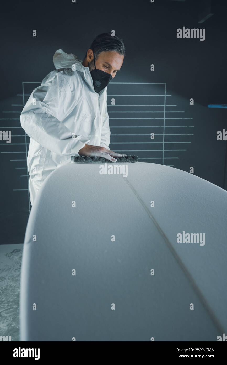 Surfboard manufacturing, Shaper working on board details. Concept of ...