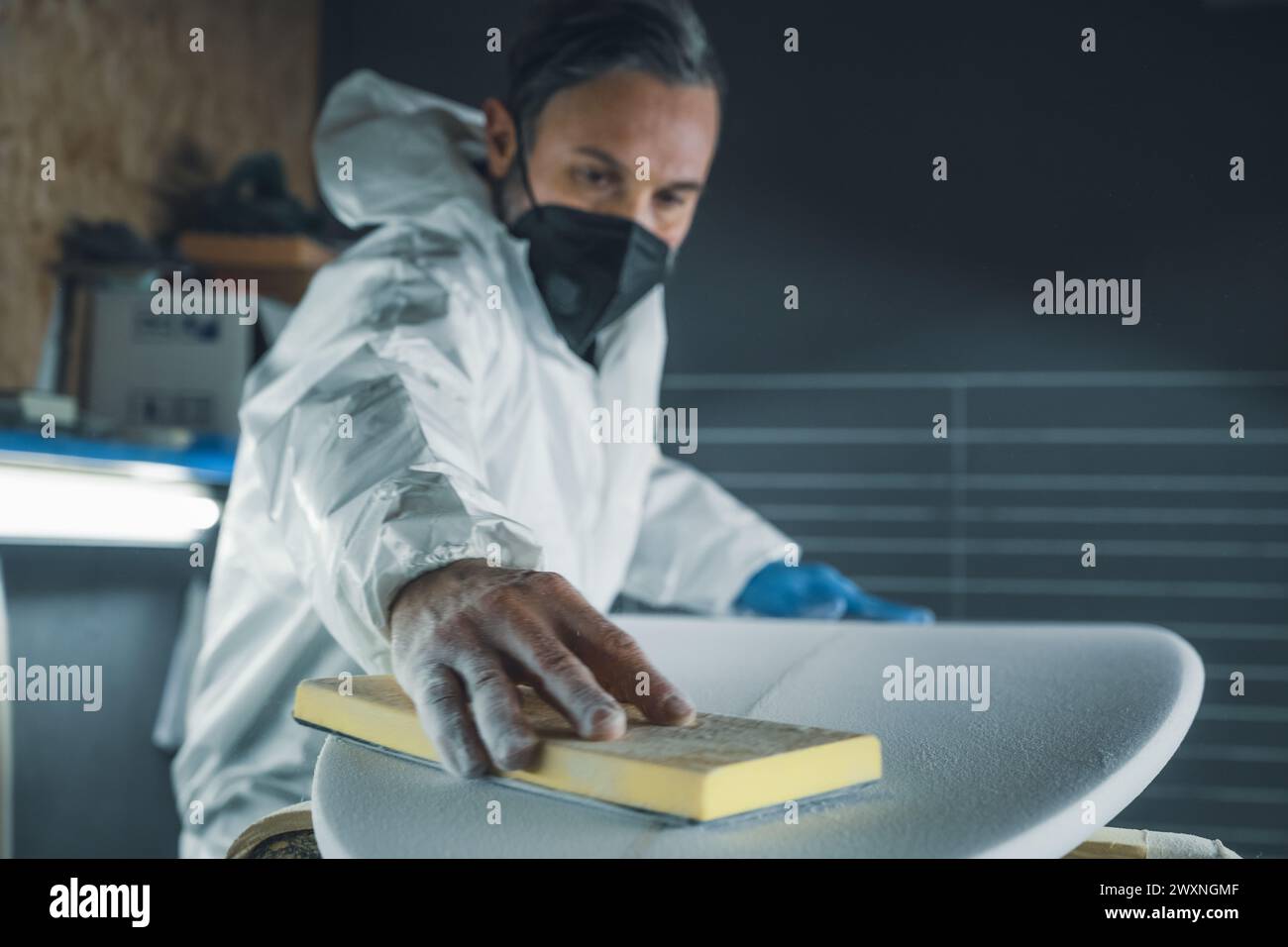 Surfboard manufacturing, Shaper working on board details. Concept of ...