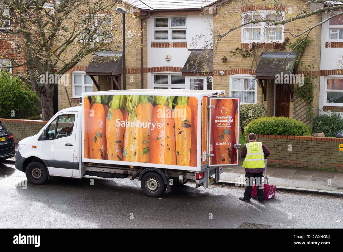 Sainsbury's delivery driver loads shopping crates from the rear of ...