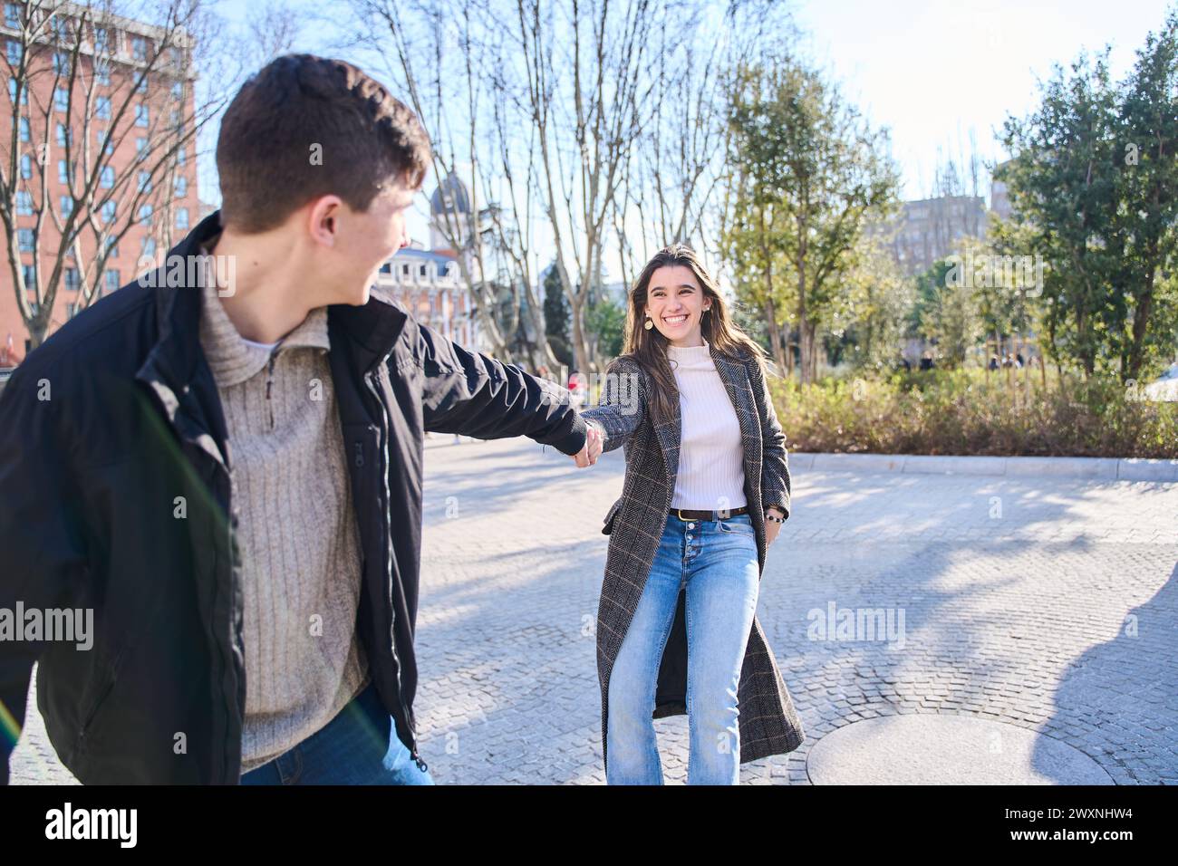 Come with me. happy young man pulling woman's hand, hand in hand ...