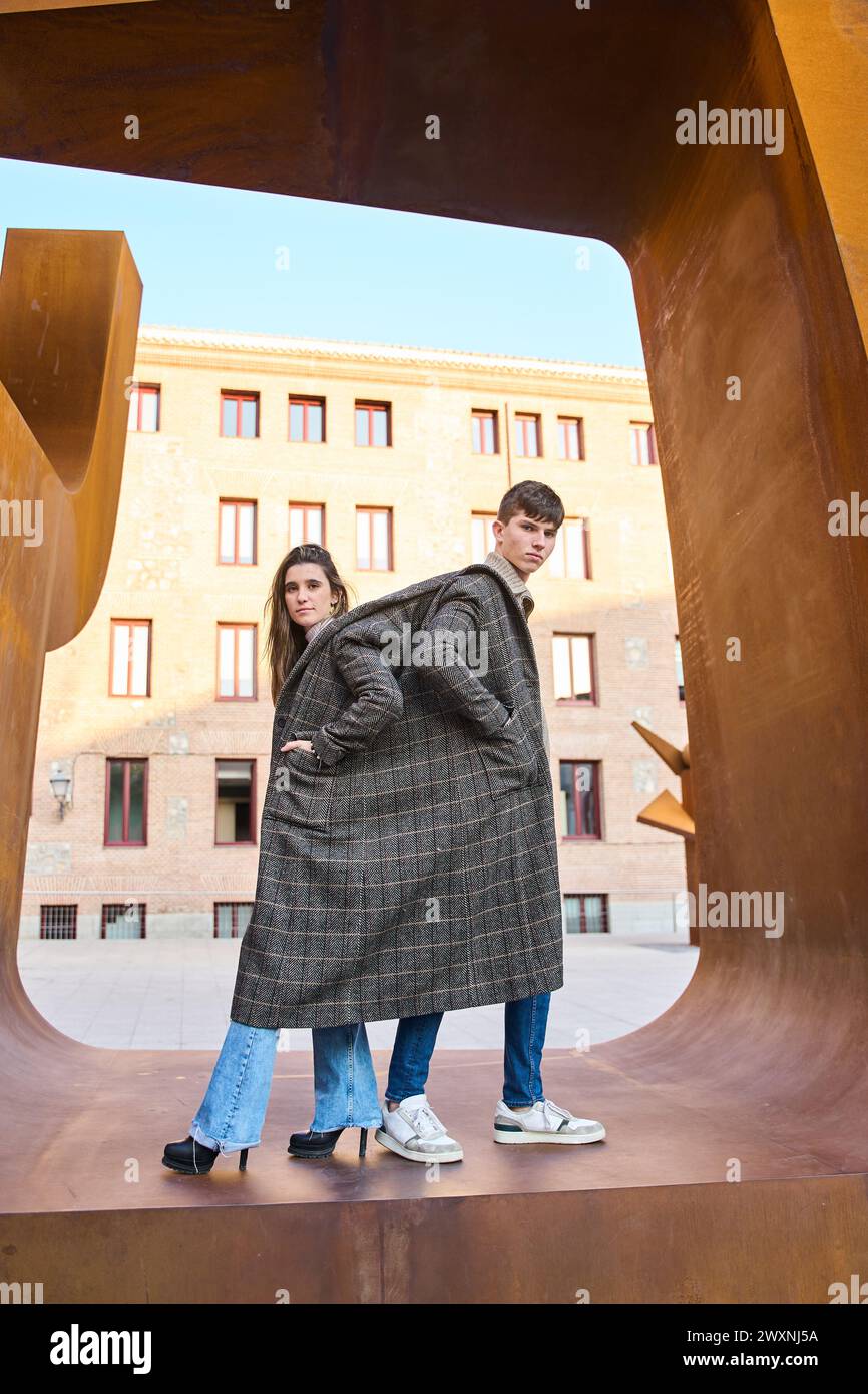 young couple sharing a coat in an artist's picture Stock Photo - Alamy
