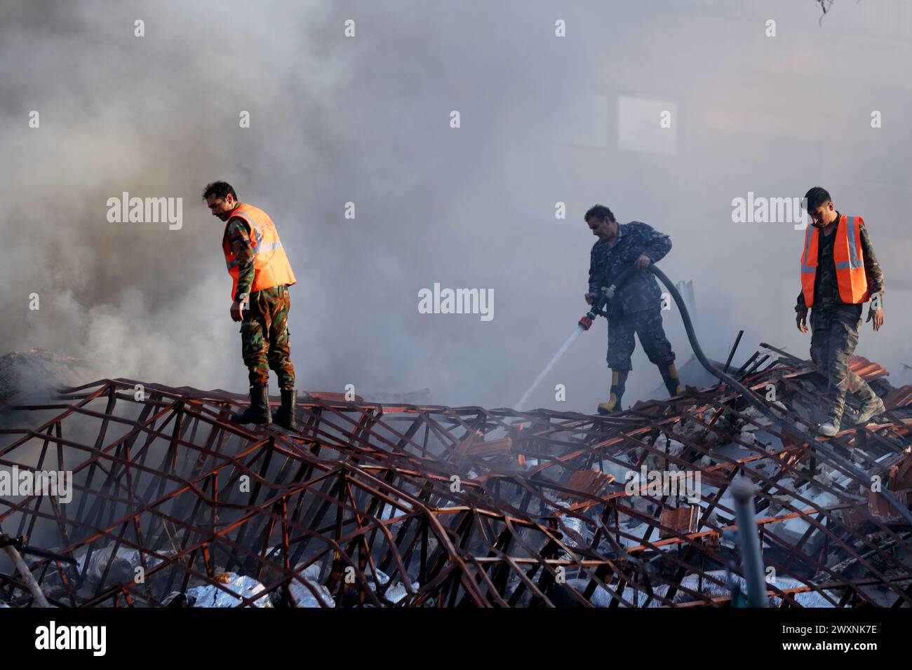 Emergency services work at a destroyed building hit by an air strike in ...