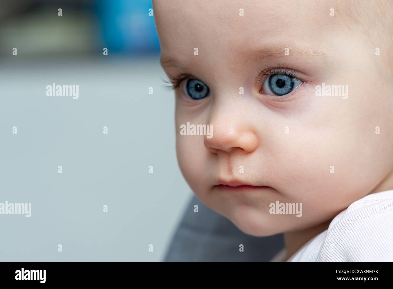 One year old baby gazes to the side with curious eyes. Concept of ...