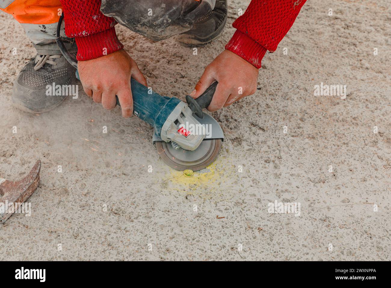 Man cutting with angle grinder in sand Stock Photo - Alamy