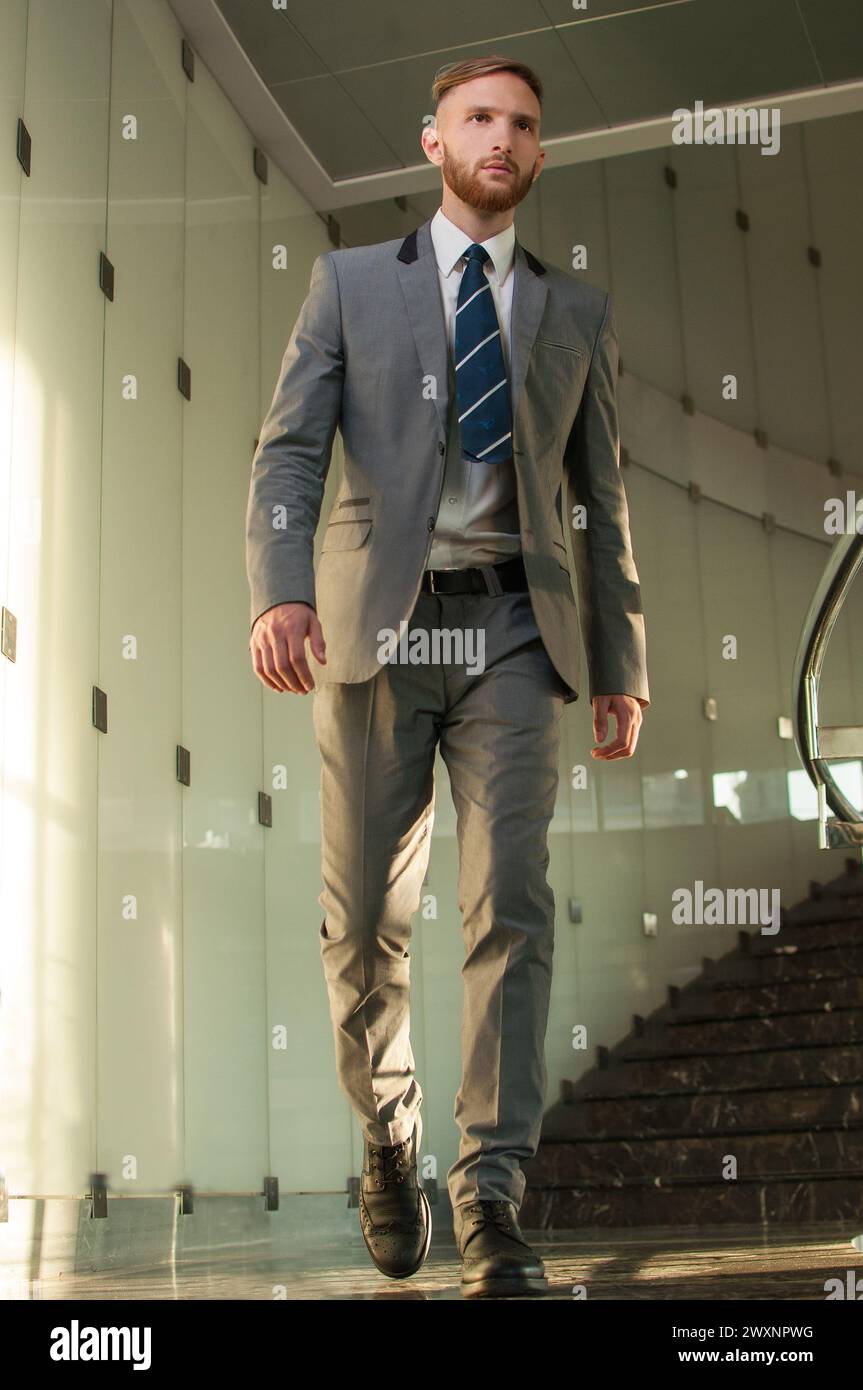 a tall man in a suit in a business center. Confident young businessman ...