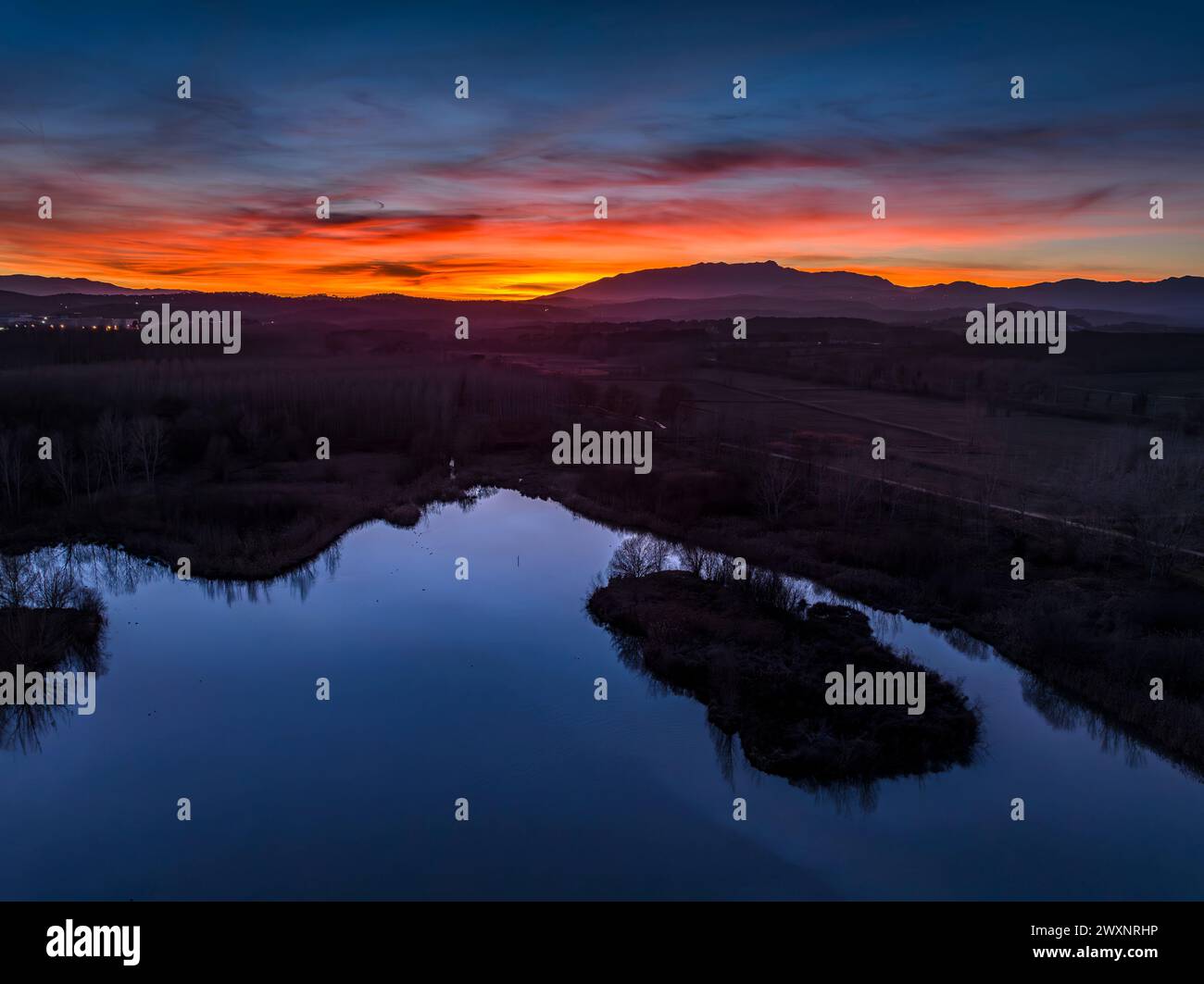 Aerial view of the Estany de Sils pond on a red winter sunset. In the ...