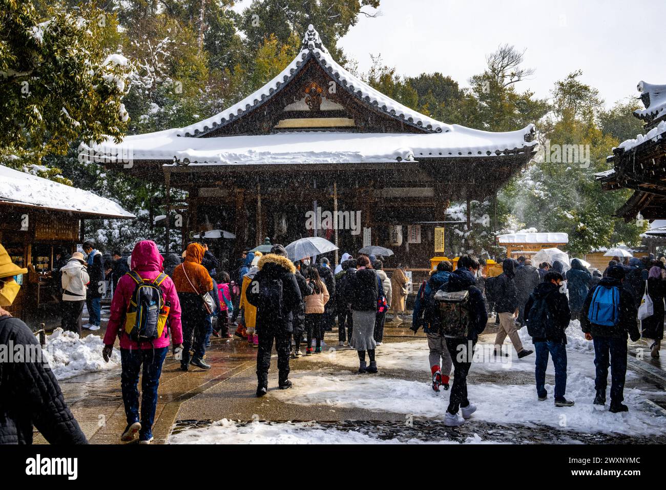 The Worshipers at a a rare snow covered Buddhist temple at Kinkaku Ji ...