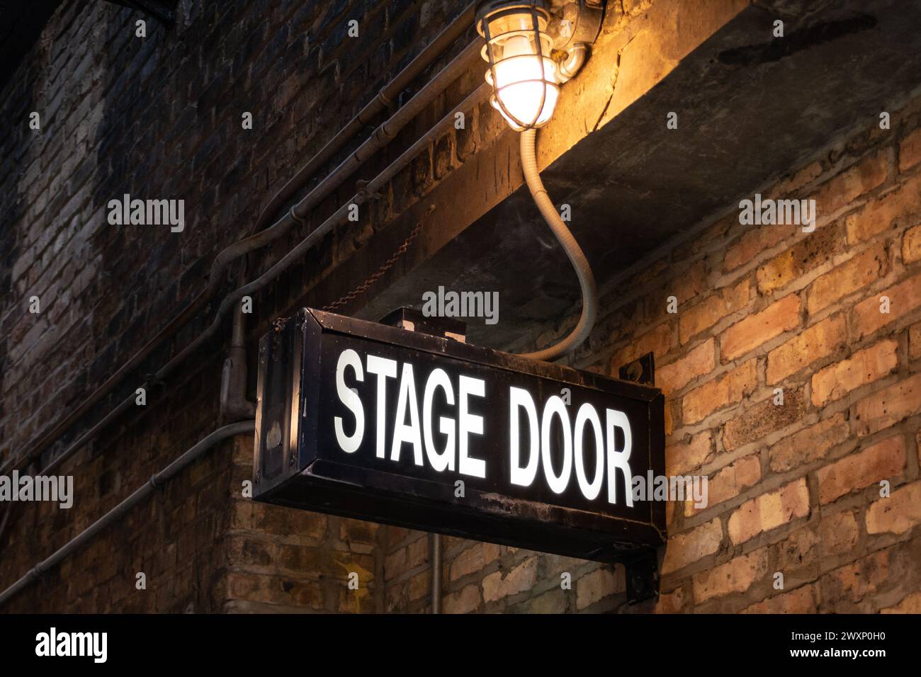 Vintage illuminated stage door sign in a dark and dingy back alley in ...