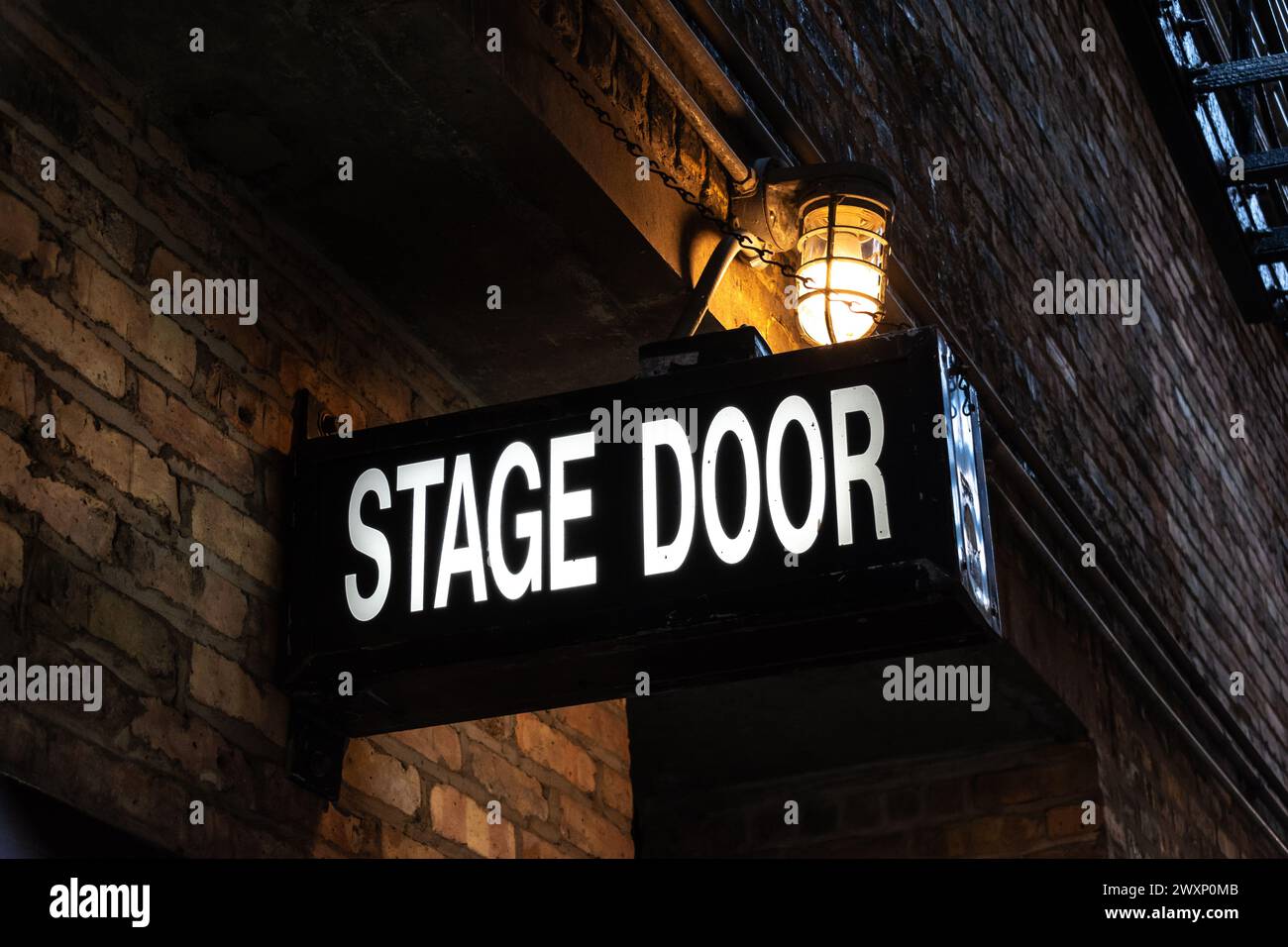 Vintage illuminated stage door sign in a dark and dingy back alley in ...