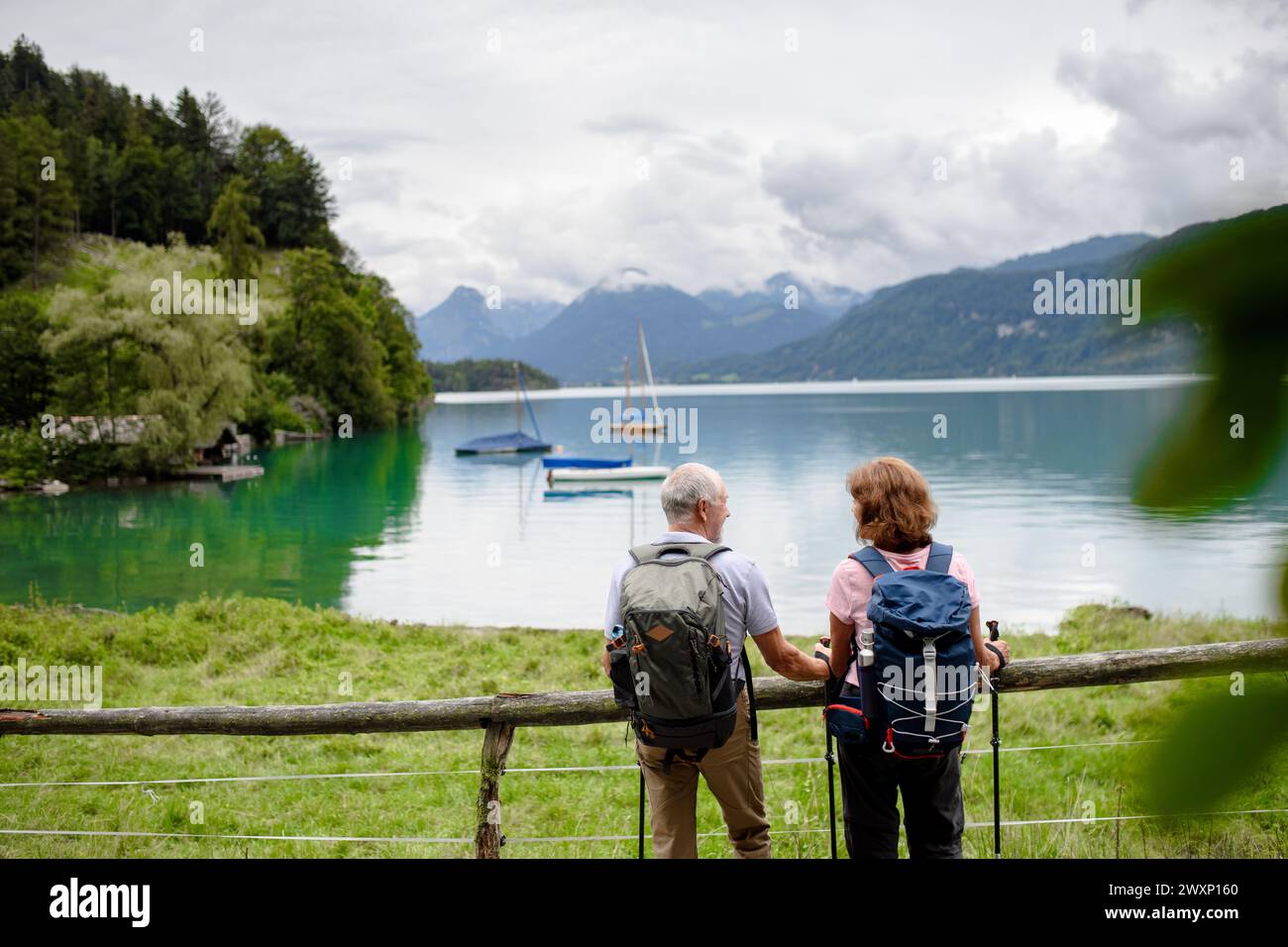 Rear view of beautiful active elderly couple hiking together in autumn mountains. Senior ...