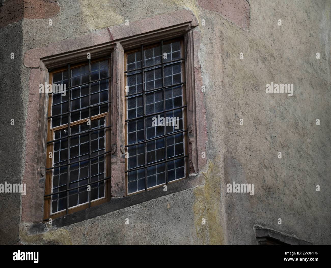 Antique window with handcrafted wrought iron grilles on a weathered ...