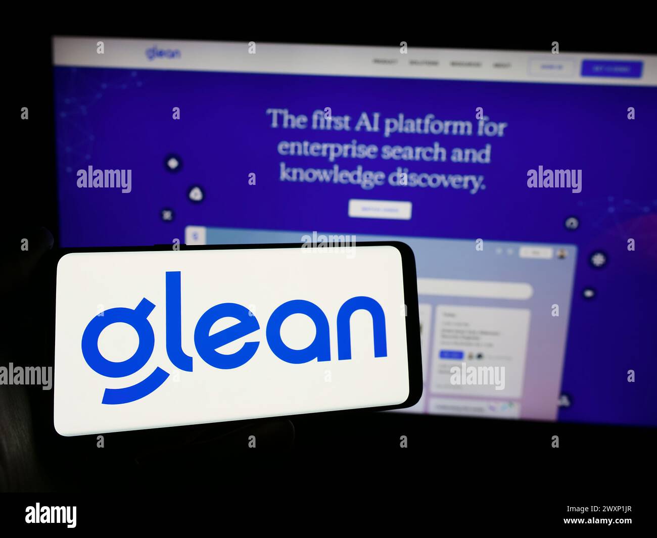 Person holding mobile phone with logo of American AI assistant company ...