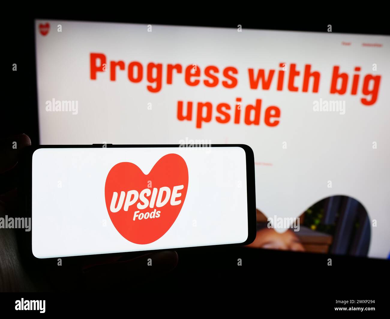 Person holding mobile phone with logo of American cultured meat company ...