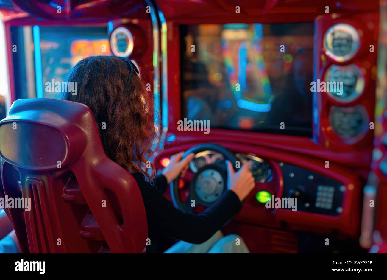Girl playing racing simulator game in theme park Stock Photo - Alamy