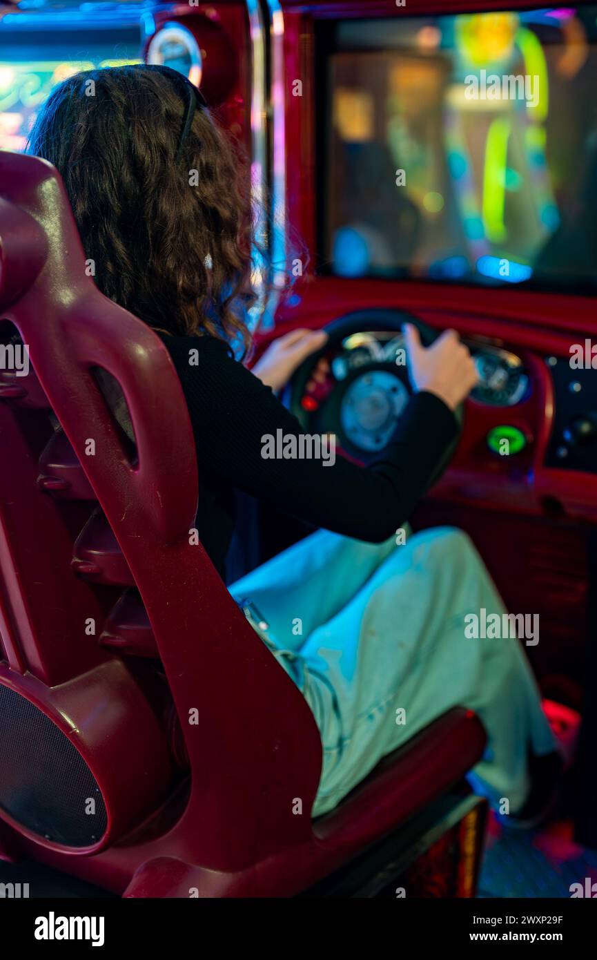 Girl playing racing simulator game in theme park Stock Photo - Alamy