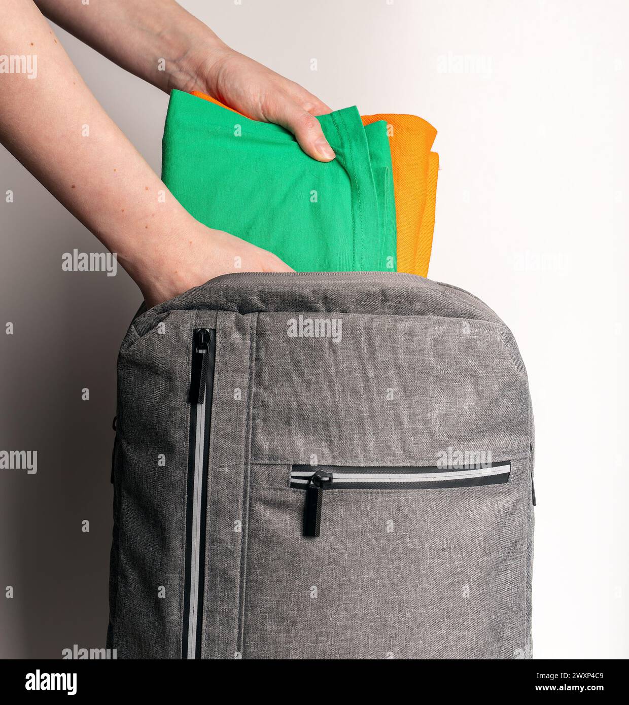 Packing clothes, garments into backpack Stock Photo - Alamy