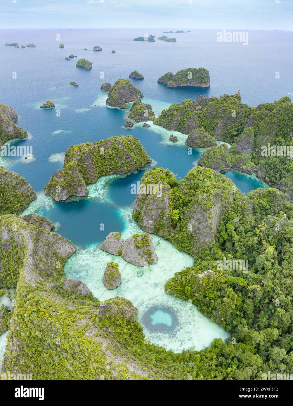 The limestone islands of Balbalol, fringed by reef, rise from Raja ...