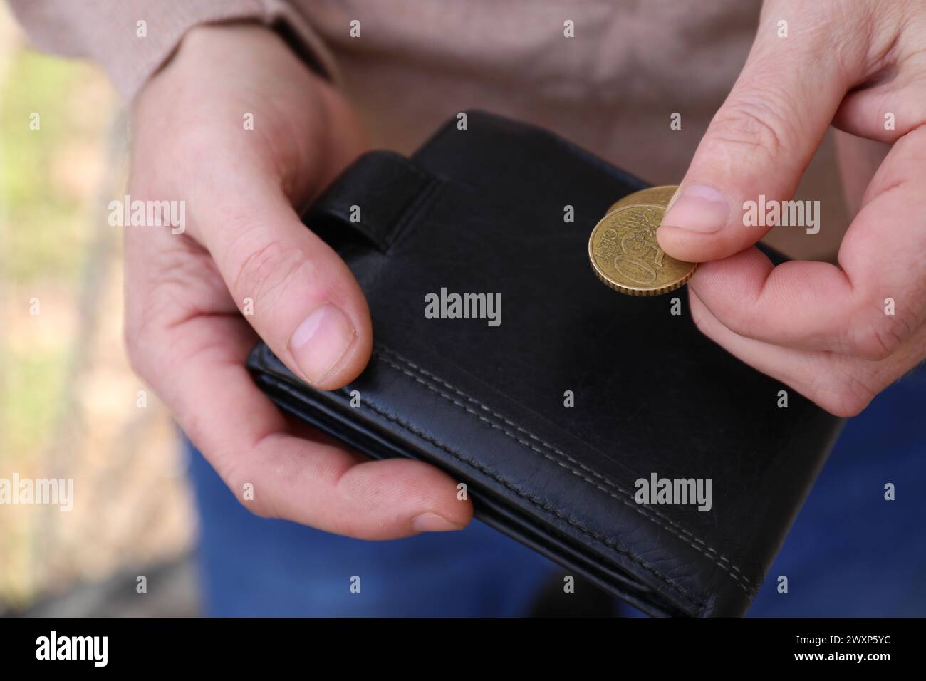 Poor man holding coins and empty wallet outdoors, closeup Stock Photo ...