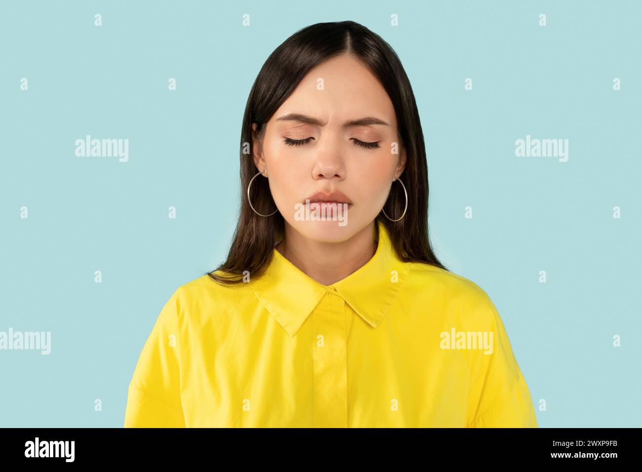 Upset emotional young woman, with eyes closed showing a vulnerable ...