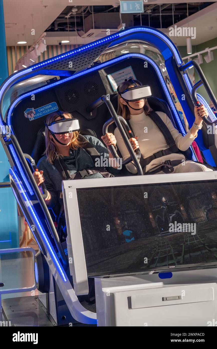 Two woman is sitting in an electric blue virtual reality chair Stock ...