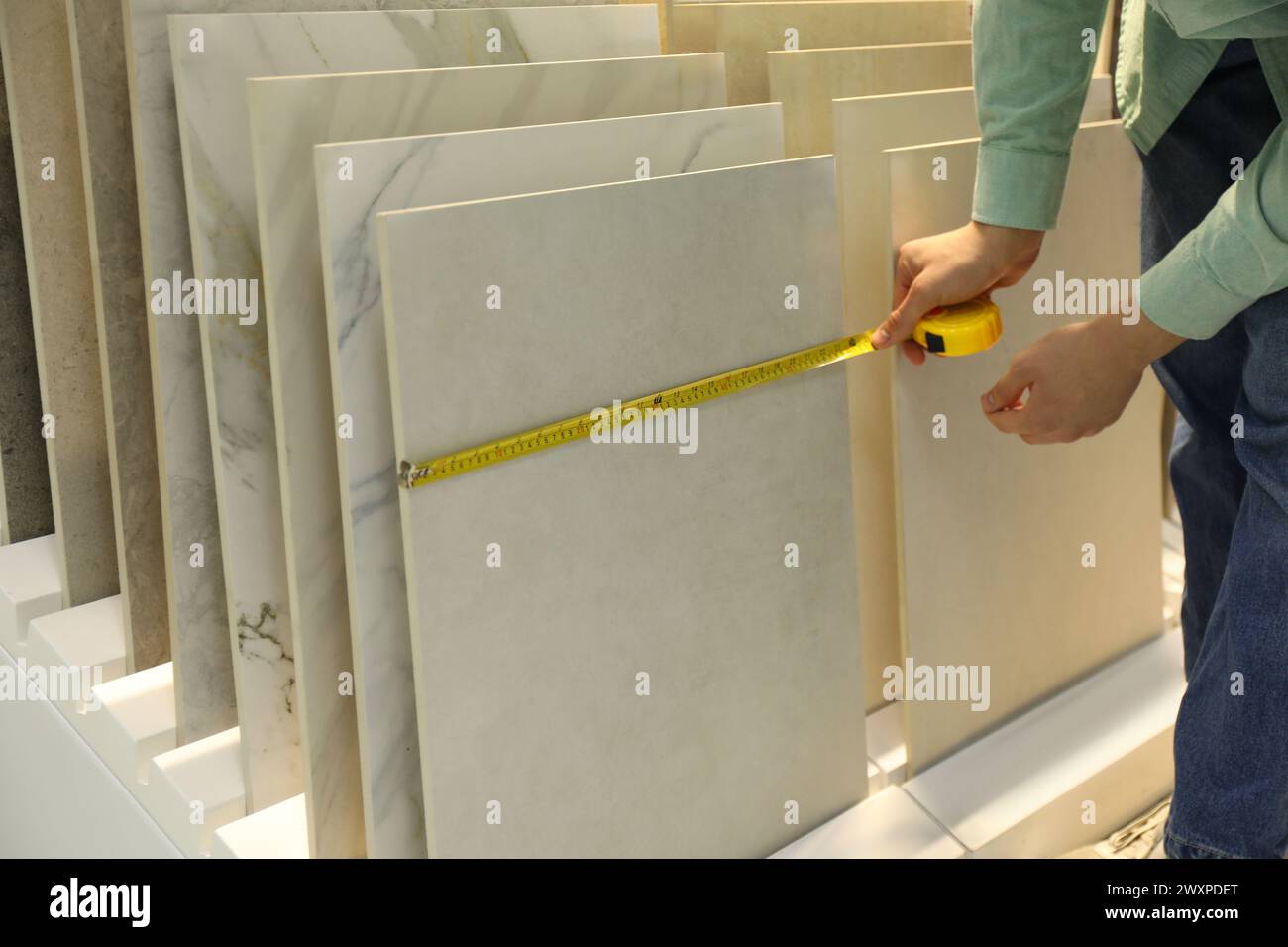 Man using tape measure while choosing tile in store, closeup Stock ...