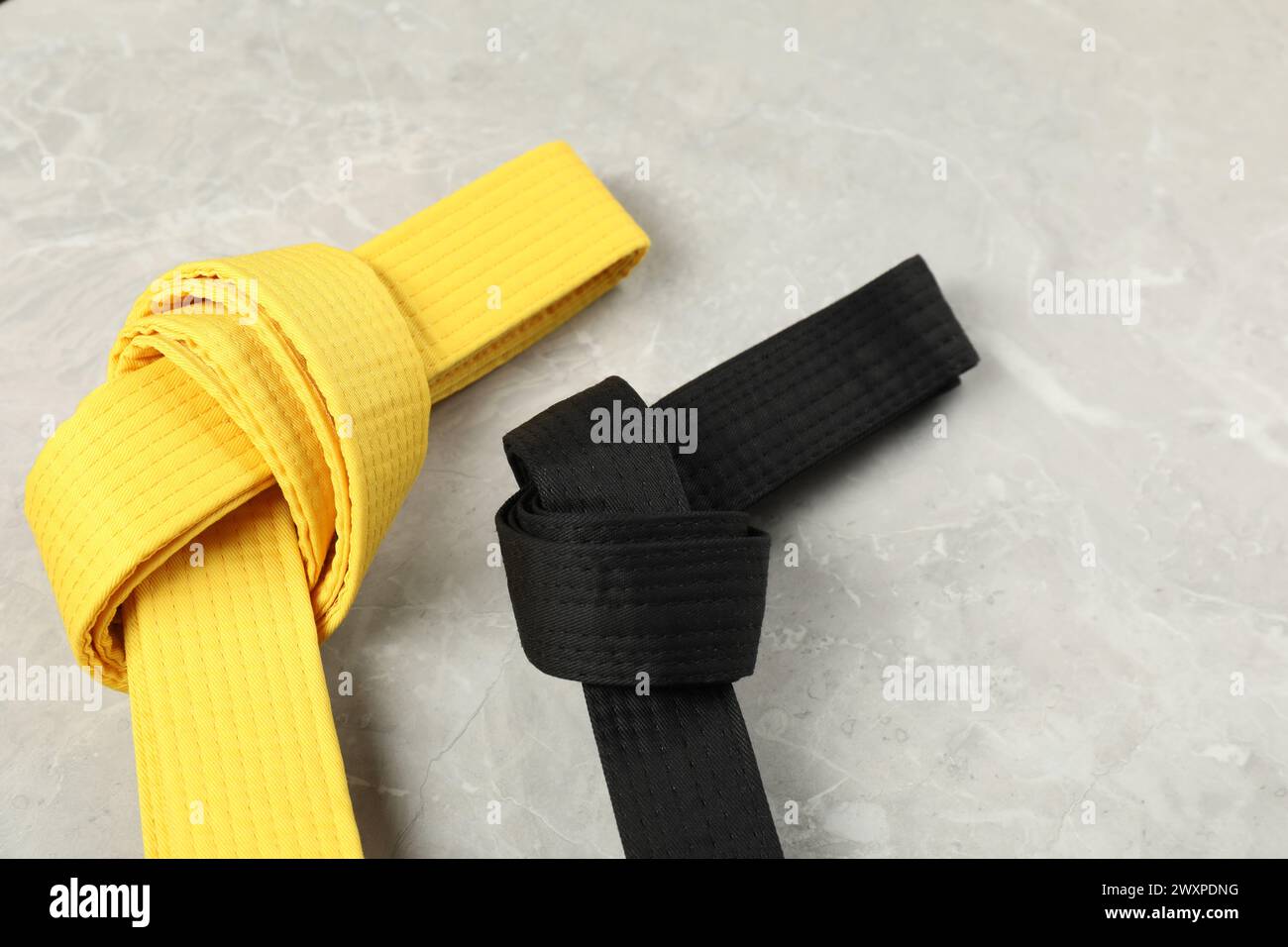 Black and yellow karate belts on gray marble background Stock Photo - Alamy